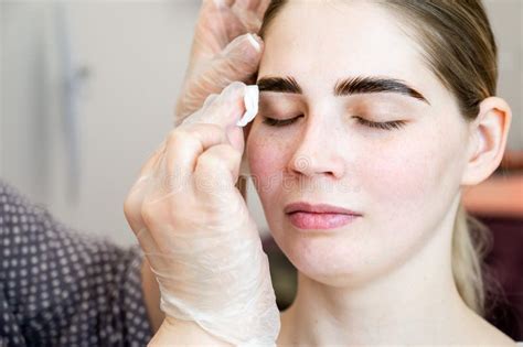 The Master Processes The Eyebrows Of A Caucasian Woman With A Cotton