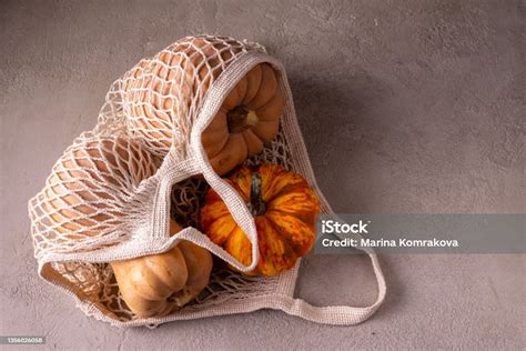 잘 익은 오렌지와 베이지 색 호박은 밝은 배경에 환경 친화적 인 재료로 만든 그물에 자리 잡고 있습니다 0에 대한 스톡 사진 및 기타 이미지 Istock