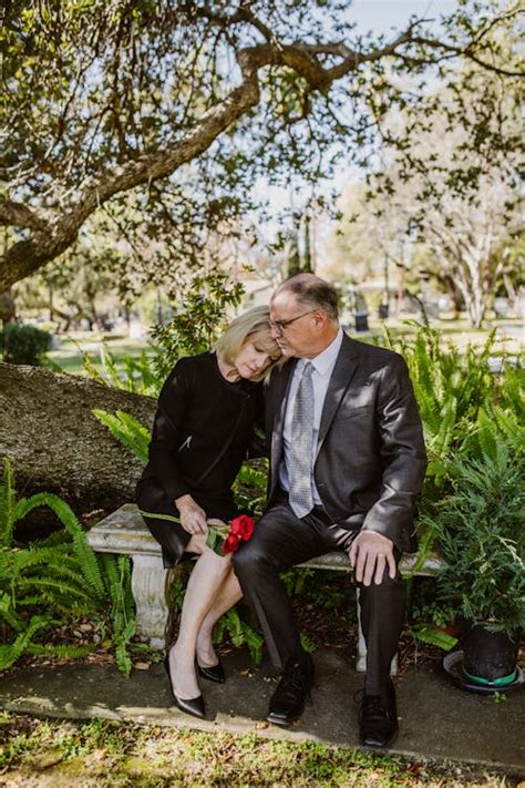 감정 감정적 힘 갓돌 검은 색 양복 검정 드레스 공물 공식적인 옷차림 공원 벤치 공원 환경 기념 정원 기념비 나무 노부부 녹지 단란함 동정 반사