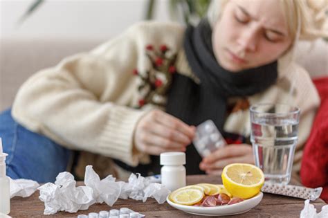 스웨터를 입은 소녀는 소파에 누워 아프다 감기와 독감 환자는 감기에 걸렸고 아픈 느낌이 들었고 치료를 위해 약을 사용합니다 건강에 해로운 소녀 감기와 독감에 대한 스톡 사진