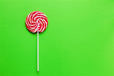 녹색 종이 배경에 밝은 빨간색과 흰색 줄무늬 막대 사탕 기하학적 대비 색상 레이아웃입니다 녹색에 빨간색 공간을 복사합니다 미니멀리즘 개념 0명에 대한 스톡 사진 및 기타