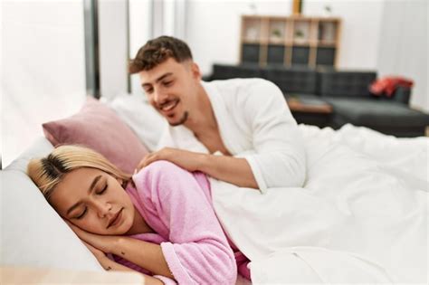 Free Photo Man Waking Up His Girlfriend Lying On The Bed At Home