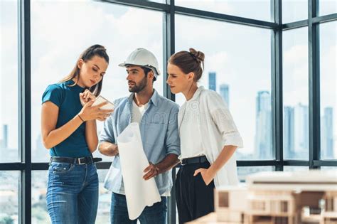 Group Of Engineer Looking At Project Plan While Brainstorming Idea