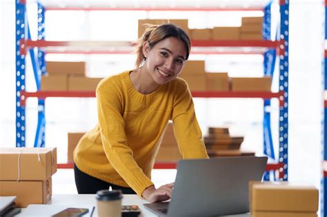 젊은 아시아 온라인 비즈니스 소유자 여성은 고객에게 배달할 패키지를 준비하기 위해 소포 상자를 준비하고 있습니다 온라인 중소기업