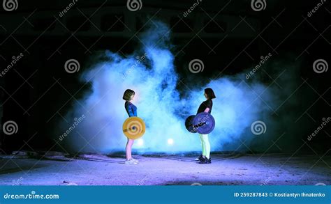 Two Athletic Girls Athletes Raise The Barbell Do Sit Ups With The