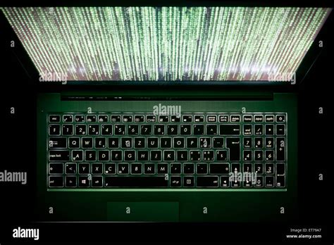 A Laptop Computer In The Dark With Illuminated Keyboard And Mystic Program Code On Screen Stock