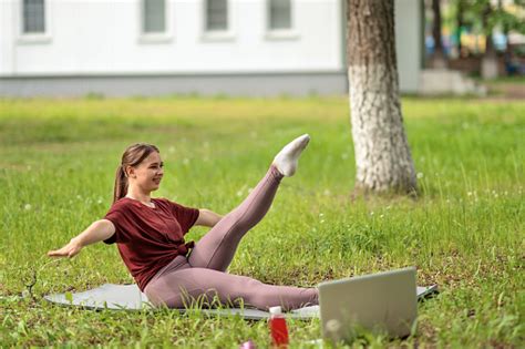 확대축소 또는 스카이프를 통해 가이드 또는 온라인 트레이너 지침에 따라 야외에서 스포츠를하는 소녀 18 19세에 대한 스톡 사진