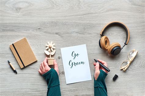 개념 제로 폐기물 의식 소비 플랫 누워 트렌디 한 나무 꽃과 마커를 들고 손의 상단보기 텍스트 녹색 이동 공예 골판지 몰스킨 노트북 나무에 안경과 이어폰을 읽기 감소에 대한