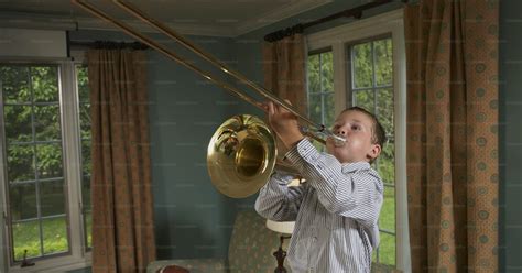 거실에서 트롬본을 연주하는 어린 소년 사진 Unsplash의 소음 이미지