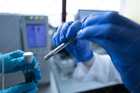 Scientist Injecting A Sample Via The Autosampler Of HPLC System High Performance Liquid