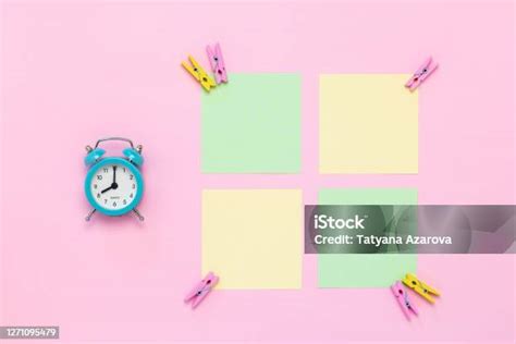 게시판에 4개의 빈 스티커 기획 컨셉 텍스트를 위해 배치하고 공간을 복사합니다 분홍색 배경에 옷핀과 알람 시계가있는 다채로운