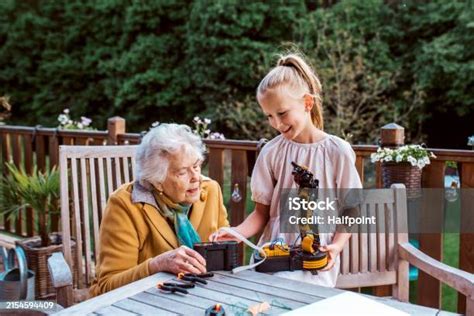 로봇 공학 과학 It 기술 및 프로그래밍 분야에서 손녀를 지원하는 할머니 간단한 로봇을 조립하여 할머니에게 밀어 넣는 어린 소녀 2명에 대한 스톡 사진 및 기타 이미지