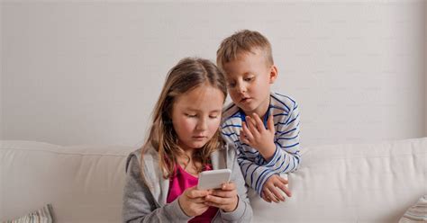 어린 소녀와 소년은 집에서 스마트 폰으로 소파에 앉아 있습니다 실내에서 노는 행복한 아이들 복사 공간 사진 Unsplash의 아이 전화 이미지