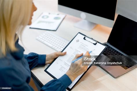 비즈니스 우먼 회사 이사 회사의 고용 전문가 현대 사무실의 책상에 앉아 채용 인터뷰를 진행하고 후보자의 이력서를 집중적으로 읽고 결정을 내립니다 2명에 대한 스톡 사진 및