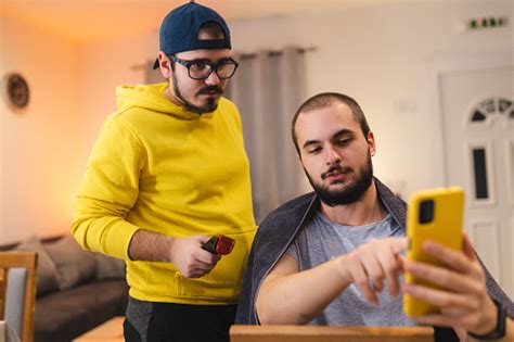 젊은 남자 보여주는 그의 이발물 의 종류 그는 그의 스마트폰에 원하는 이발 때문에 전염병에 집에서 이발을 하기 전에 20 24세에 대한 스톡 사진 및 기타 이미지 Istock