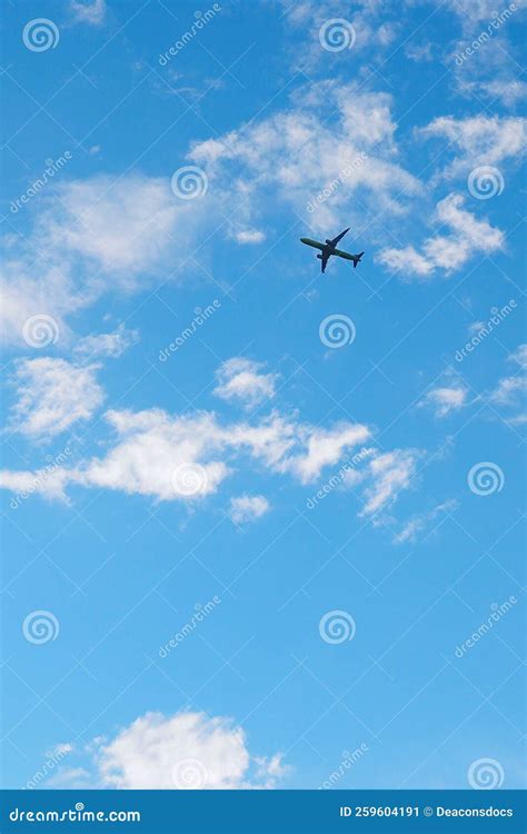 The Passenger Airplane Is Flying Far Away In The Blue Sky And White Clouds Plane In The Air