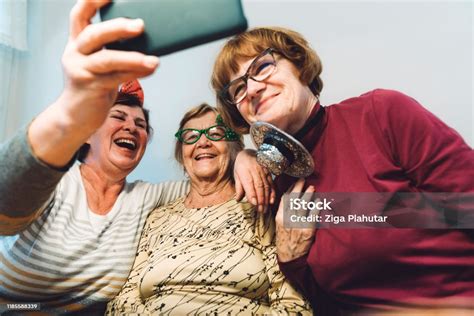 Group Of Happy Senior Women In Party Attire Taking Selfies With A Smart