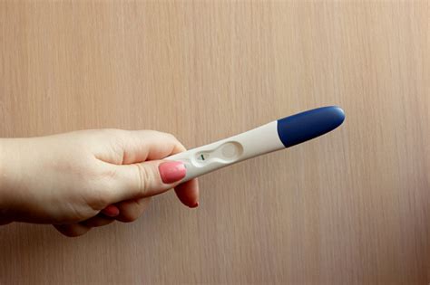 여자는 가벼운 배경에 부정적인 임신 테스트를 들고 분홍색 손톱과 손입니다 모성 임신 피임의 개념 건강 문제 및 임신 문제 복사 공간 가족에 대한 스톡 사진 및 기타 이미지