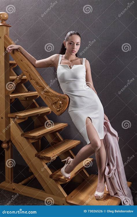 Portrait Of Brunette In The Studio In A White Skin Tight Dress Stock