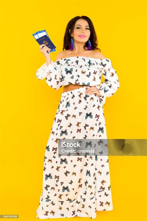 나비와 실크 드레스를 입은 귀여운 아시아 여성이 노란색 배경에 여권과 항공권을 들고 있다 나비에 대한 스톡 사진 및 기타 이미지 나비 스튜디오 촬영 여자 Istock