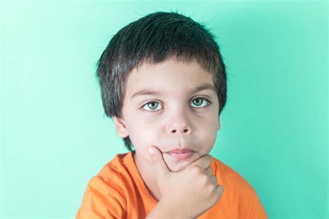 Мальчик в оранжевой футболке с забавным лицом Бесплатно Фото