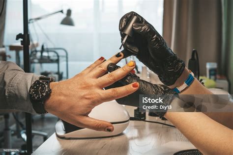 남자는 매니큐어를 가져옵니다 남자의 손톱의 착색 남성 매니큐어의 디자인 남자의 손에 검은 매니큐어를 적용 하는 여자 가까이 촬영 Lgbtqia 문화에 대한 스톡 사진 및
