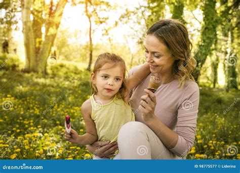 Mutter Und Tochter Die Auf Dem Gras Sitzen Stockbild Bild Von