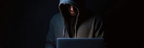 Premium Ai Image Hacker Without Face In A Hood Holds A Laptop On A Background Banner For Cyber