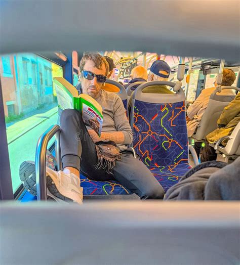 man reading a book inside a passenger bus editorial photography image