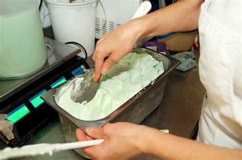 요리사 유니폼에 제과 아이스크림 공장에서 일하고 있다 여자는 강철 컨테이너에 이탈리아 크림 민트 아이스크림 맛의 훈장 이다 제조 산업 생산 사람들 개념입니다 강철에 대한