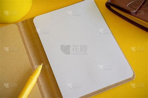 黄色背景上的记事本和钢笔