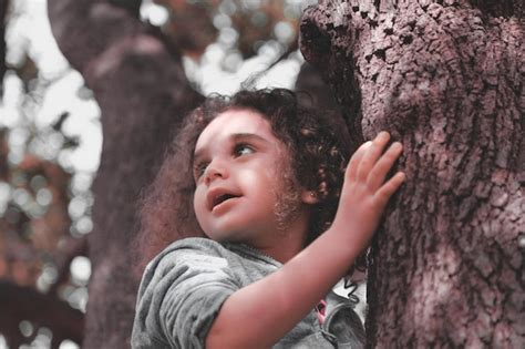 Premium Photo Smiling Boy On Tree Trunk