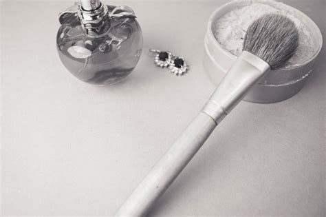 뷰티 박스 부서 지기 쉬운 매트 미네랄 파우더 메이크업 핑크 향수와 검은색과 흰색 배경에 빛나는 실버 귀걸이 대 한 자연 Nap에서 특별 한 갈색 나무 브러쉬 플랫이 하다