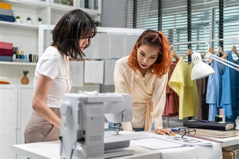 아시아 두 명의 재단사 여성이 테일러링 아틀리에에서 옷을 디자인하기 위해 일하고 있다 매력적인 젊은 여성 패션 디자이너 양장점 브레인스토밍 워크숍 룸에서 함께 새로운