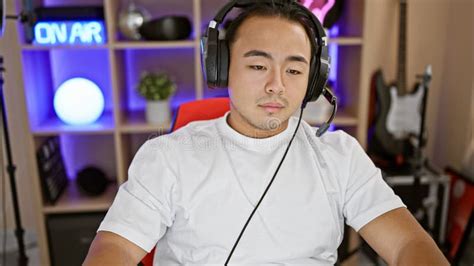 Concentrated Young Chinese Man A Tech Enthusiast Streamer Seriously Immersed In Playing A