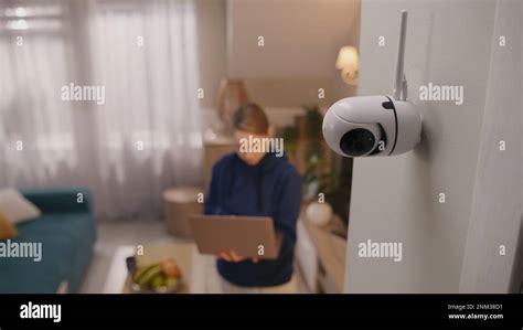 Caucasian Woman Installs Security Camera Woman Sets Up Angle Of CCTV Camera At Home And Rotates
