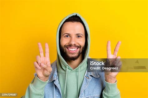 펑키한 긍정적 인 사람의 사진 빛나는 미소 손 손가락 쇼 V 기호 노란색 배경에 고립 갈색 머리에 대한 스톡 사진 및 기타