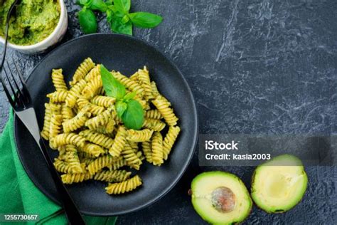 녹색 아보카도 바질 소스와 검은 색 배경에 재료 파스타 푸실리 선택적 초점 맨 위 보기입니다 공간을 복사합니다 가정 주방에 대한