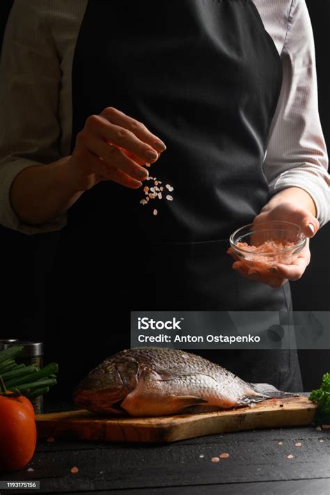 해산물 요리사는 생선 바다 소금소금을 요리하고 움직이면서 얼어 붙습니다 테이블에 재료와 검은 배경에 건강하고 건강한 음식 해산물 판매 생선 가게 수직 프레임 물고기에 대한