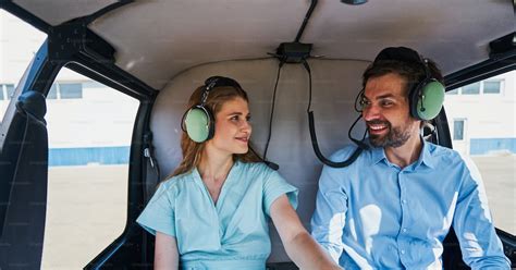 웃는 백인 여성과 헬리콥터 선실의 뒷좌석에 앉아 있는 쾌활한 남자 사진 Unsplash의 조종석 이미지