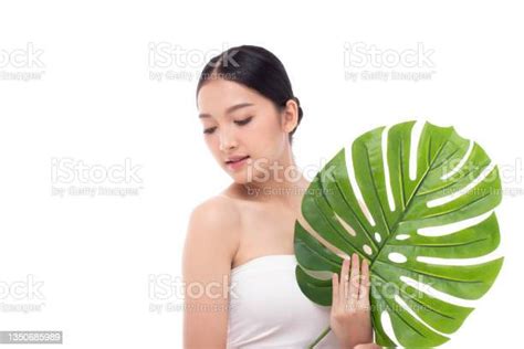 완벽한 몸부드러운 피부미를 가진 아름다운 젊은 아시아 여성의 초상화는 흰색 배경에 고립 된 열대 녹색 잎으로 자연스러운