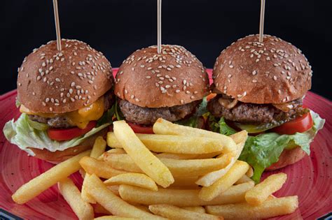 맛있는 햄버거 치즈 버거 감자 튀김 샐러드와 빨간 격자 무늬 주방 직물 테이블 탑 보기 어두운 배경에 햄버거 나 치즈 버거 감자 튀김과 케첩 세 가지 3가지 개체에 대한