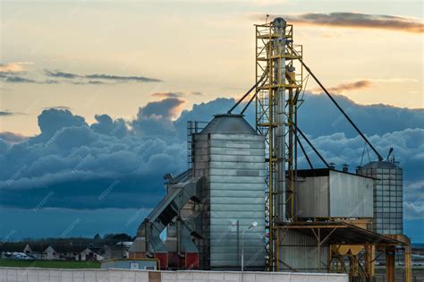 건조 청소 및 농산물 저장을 위한 농업 제조 공장의 은 사일로 밀가루 곡물 및 곡물 곡물의 대형 철 배럴 곡물 창고 엘리베이터 프리미엄 사진