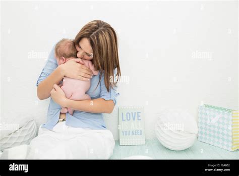 Mother Cradling Baby In Arms High Resolution Stock Photography And