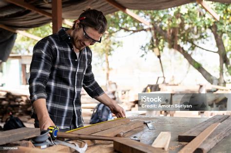 목공 작업장에서 측정 테이프를 사용하여 남성 목수 직장에서 테이프 측정으로 작업 하는 안전 고글을 착용 하는 조인 20 24세에