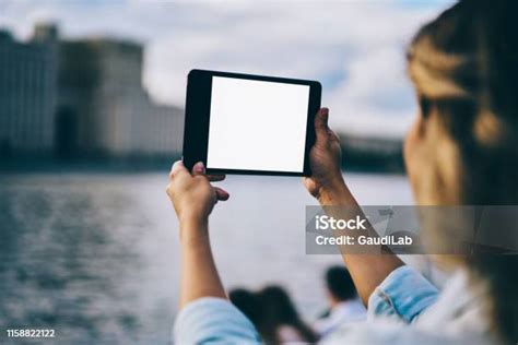 야외에 서서 광고 콘텐츠에 대한 빈 화면으로 터치 패드를 들고 여자의 자른 이미지 복사 공간이있는 디지털 태블릿에서 풍경 사진을