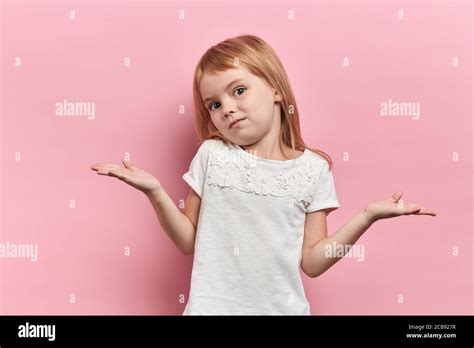 Lovely Beautiful Girl With Raised Arms Shrugging Her Shoulders