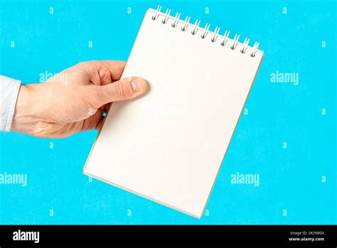 Man Hand Holding A Notebook With Blank Sheets For Writing Stock Photo Alamy