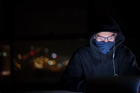 Hacker Using Laptop Computer While Working In Dark Office 12438052