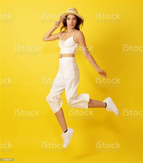 노란 배경 앞에서 흰 드레스를 입고 밀짚 모자를 쓰고 점프하는 아름다운 젊은 여성 여자에 대한 스톡 사진 및 기타 이미지 여자 행복 한 명의 여자만 Istock
